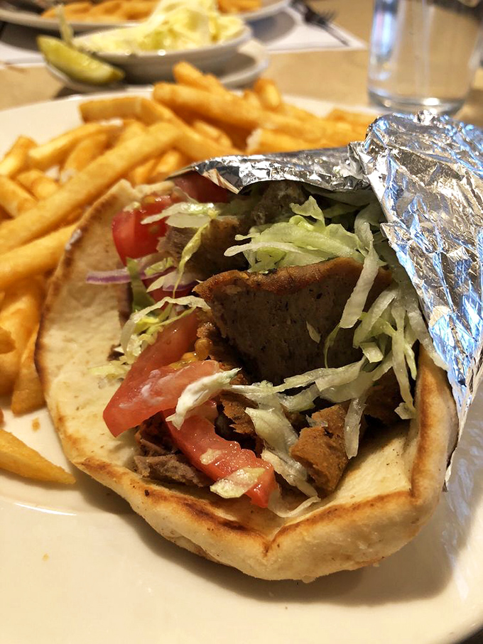 This isn't just a gyro—it's an edible architecture project where crispy, savory meat meets garden-fresh veggies in a warm pita embrace.