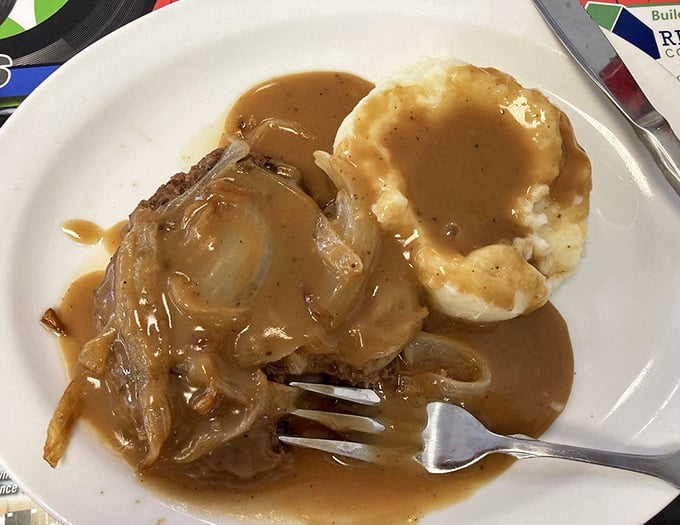 Hamburger steak swimming in savory gravy alongside creamy mashed potatoes – comfort food that speaks the universal language of "everything's gonna be alright."