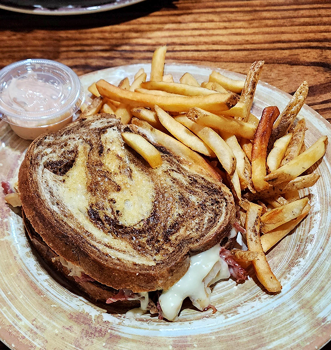 Hand-cut fries that actually taste like potatoes—what a concept!—paired with a sandwich that requires both hands and possibly a strategy session.