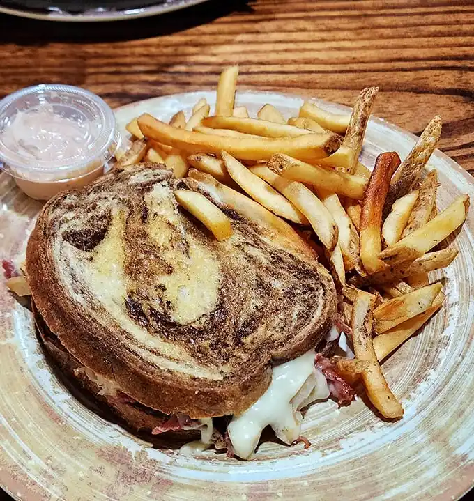 Hand-cut fries that actually taste like potatoes—what a concept!—paired with a sandwich that requires both hands and possibly a strategy session.