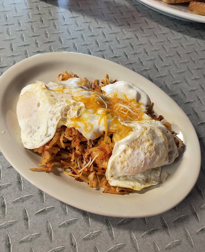 This isn't just breakfast – it's edible architecture. Crispy hash browns supporting two sunny eggs like a foundation holding up the morning's possibilities.