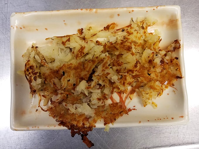 These hash browns have achieved the golden-brown perfection that home cooks dream about – crispy, buttery potato magic on a humble plate.