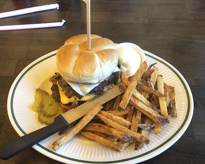 Not just a burger—a commitment. Hand-cut fries standing at attention beside a sandwich that requires both hands and possibly a nap afterward.