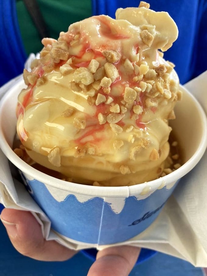Vanilla soft-serve wearing its Sunday best—caramel drizzle and crushed nuts creating that perfect sweet-salty tango in every spoonful.