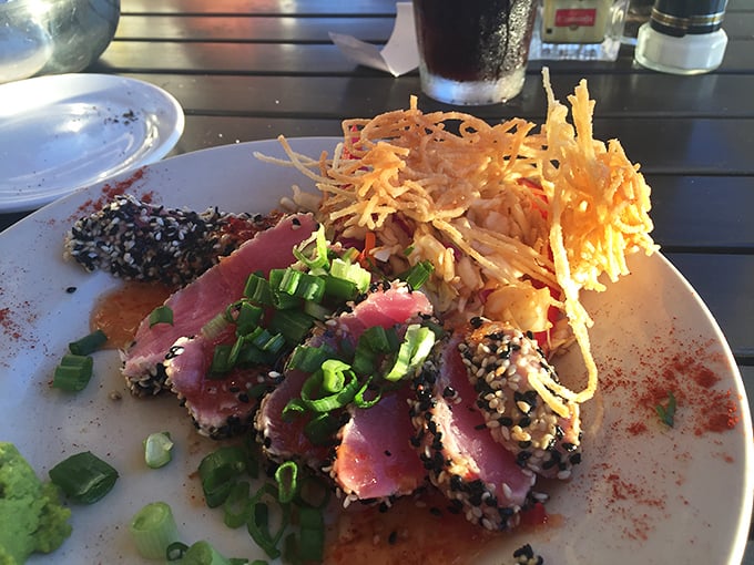 Sesame-crusted tuna that's living its best life—seared on the outside, blushing on the inside, with crispy garnish adding textural fireworks.