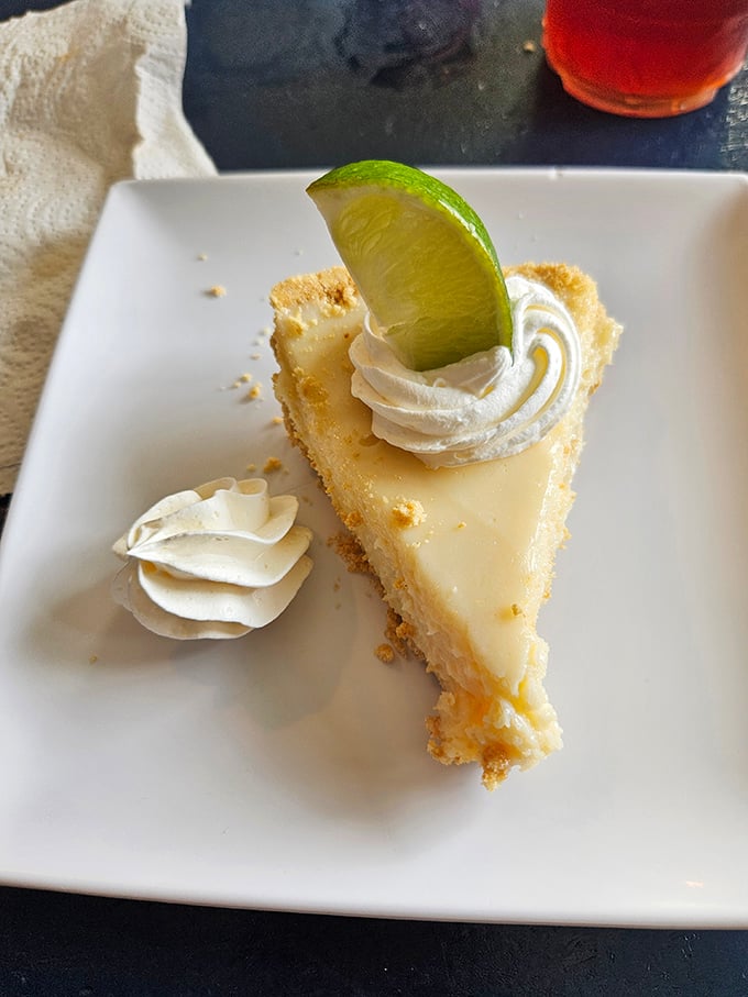 Key lime pie that strikes the perfect balance between tart and sweet, topped with a dollop of whipped cream and that essential lime wedge.