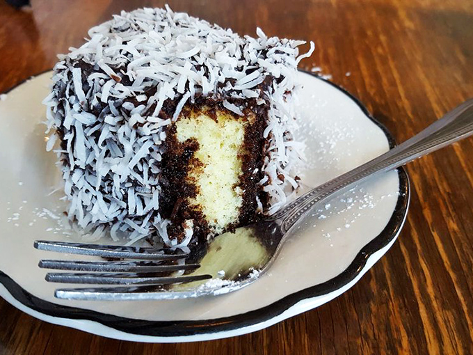 The lamington—Australia and New Zealand's gift to the world. Chocolate-dipped sponge cake rolled in coconut creates a textural paradise worth every calorie.