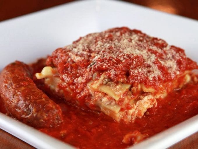 Lasagna that doesn't just sit on the plate – it tells a story, layer by delicious layer, with a sausage sidekick that refuses to be upstaged.