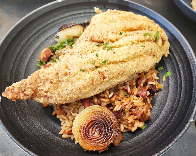 Crispy on the outside, tender within—this catfish proves that sometimes the simplest preparations deliver the most profound flavors.