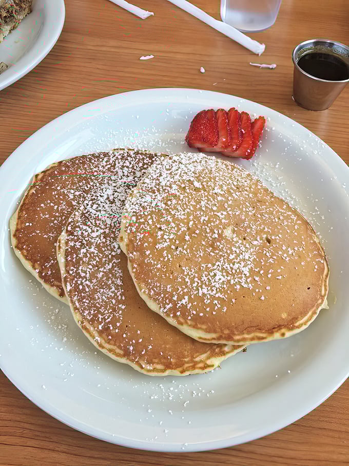 Golden pancakes dusted with powdered sugar and crowned with fresh strawberries—the breakfast equivalent of winning the lottery.