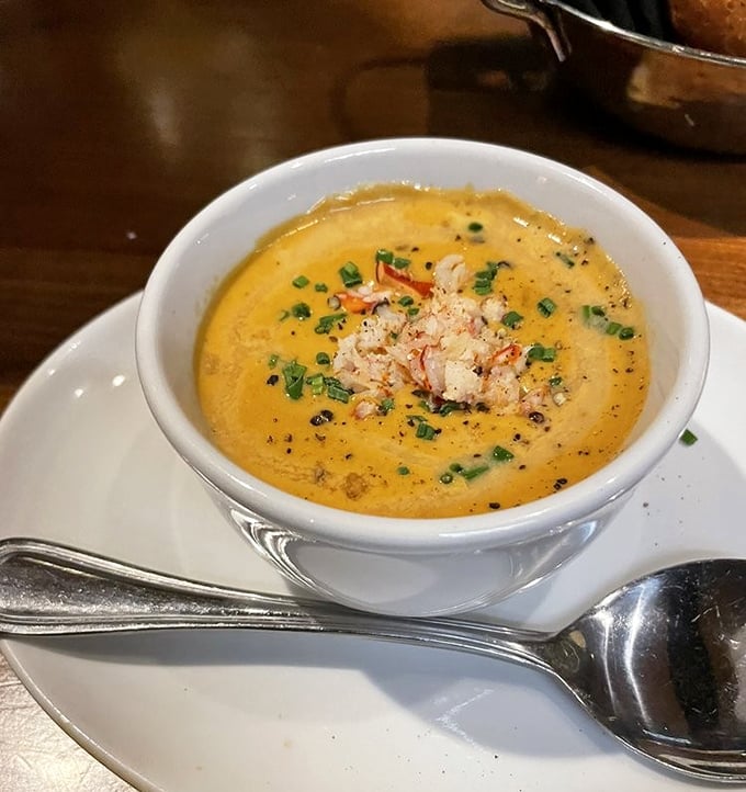 The lobster bisque arrives like liquid velvet in a bowl, topped with delicate chunks of lobster meat and fresh herbs—soup that demands to be savored, not just eaten. 