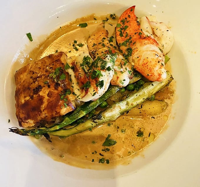 A seafood masterpiece that marries delicate lobster with spring vegetables in a buttery sauce—proof that sometimes the ocean's finest treasures belong on land.