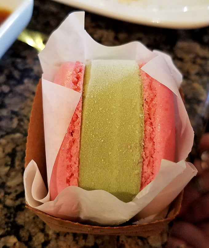 A dessert that looks like it escaped from a Wes Anderson film—layers of matcha and strawberry macaron sandwiching ice cream in a delightful color story.