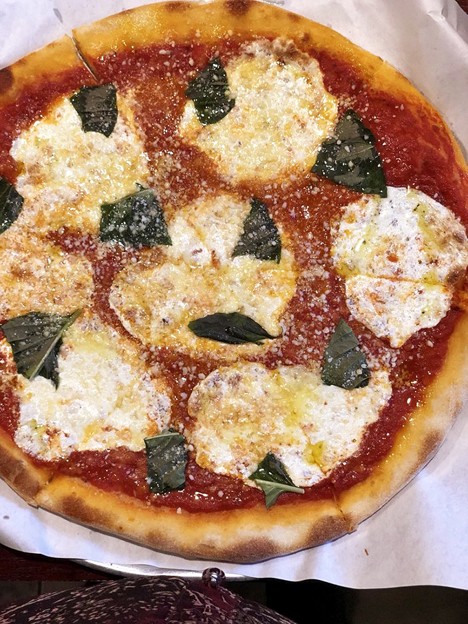 The Margherita pizza – that magical trinity of bright tomato sauce, melted fresh mozzarella, and aromatic basil – executed with the reverence this Italian classic deserves.