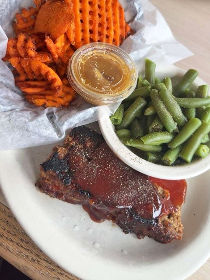 This meatloaf doesn't need a fancy introduction—it's wearing a BBQ sauce tuxedo and brought green beans and sweet potato fries as its plus-ones.