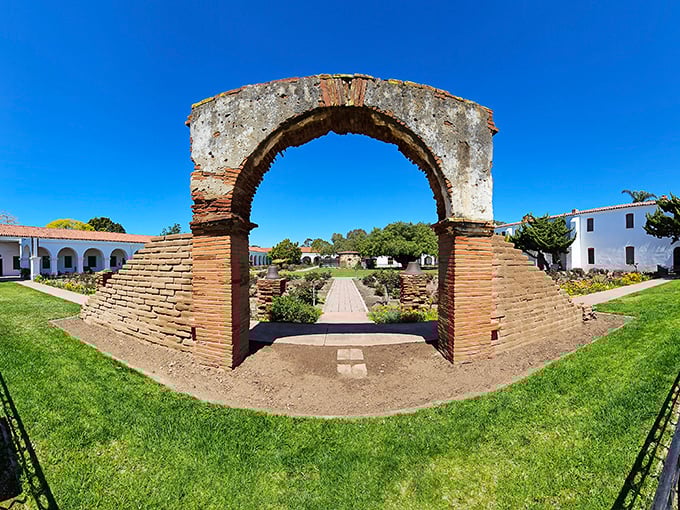 The historic archway at Mission San Luis Rey frames centuries of California history, offering a peaceful respite from beach activities and a glimpse into the past.