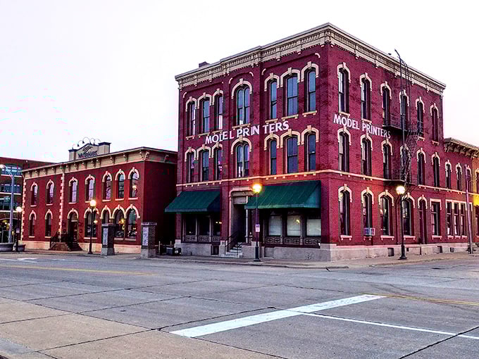 The Model Printers building stands as a crimson testament to Moline's industrial heritage, its brick façade weathered by a century of Midwestern seasons.