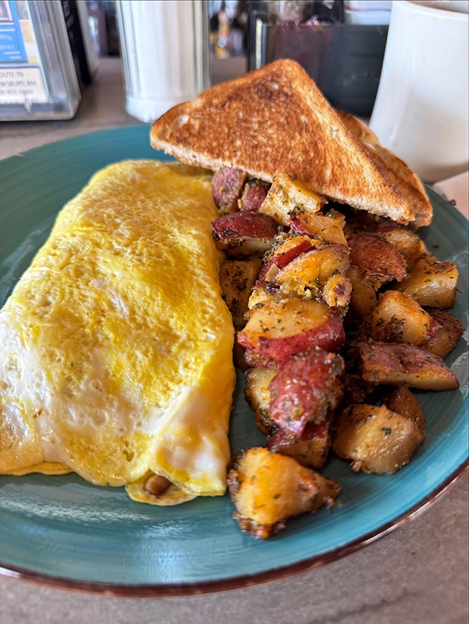 This omelet doesn't just contain cheese—it embraces it, while those home fries have clearly been introduced to seasonings that respect their potential.