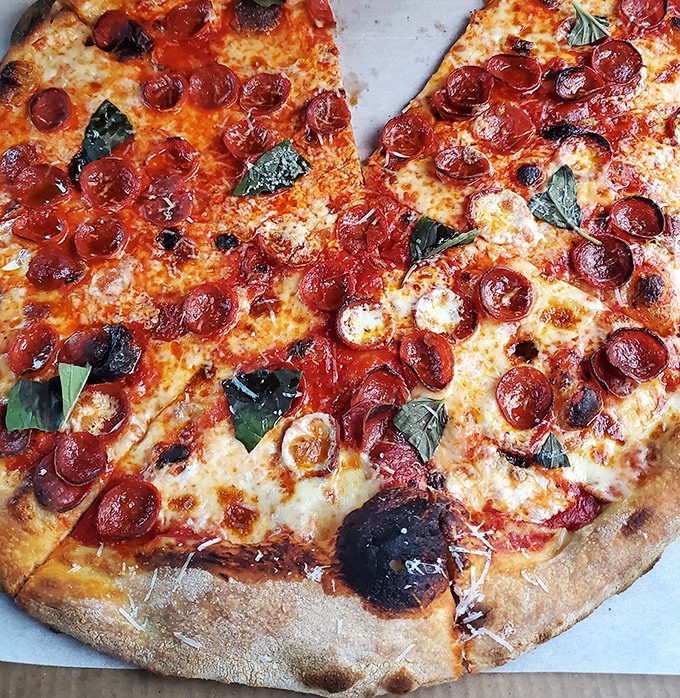 Behold the perfect New York-style slice – thin enough to fold, substantial enough to satisfy, and topped with just the right amount of everything good.
