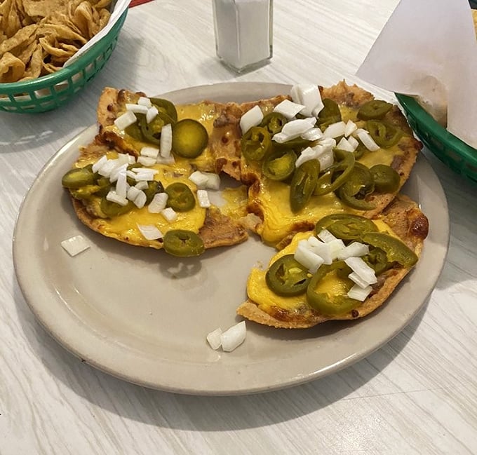 Nachos that respect the fundamentals: homemade chips, melted cheese, jalapeños, and diced onions. No architectural showboating, just pure satisfaction.
