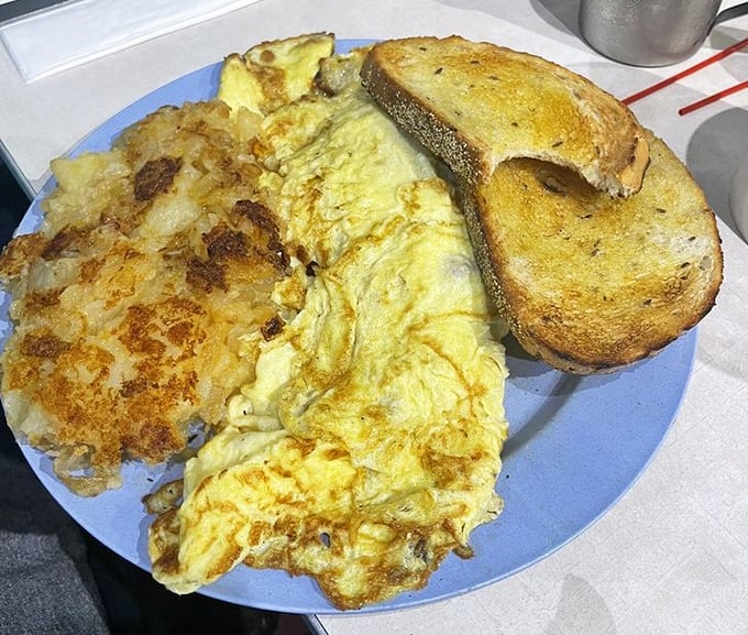 This isn't just an omelet—it's a fluffy yellow pillow of breakfast joy paired with those legendary Lyonnaise potatoes.