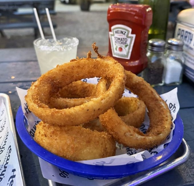 These onion rings aren't playing games – golden-brown halos of crunch that make ketchup feel like it won the condiment lottery.