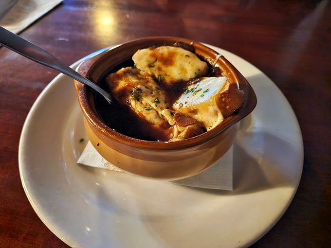 French onion soup that doesn't just warm your body but hugs your soul—a bubbling cauldron of comfort topped with golden, melted cheese.