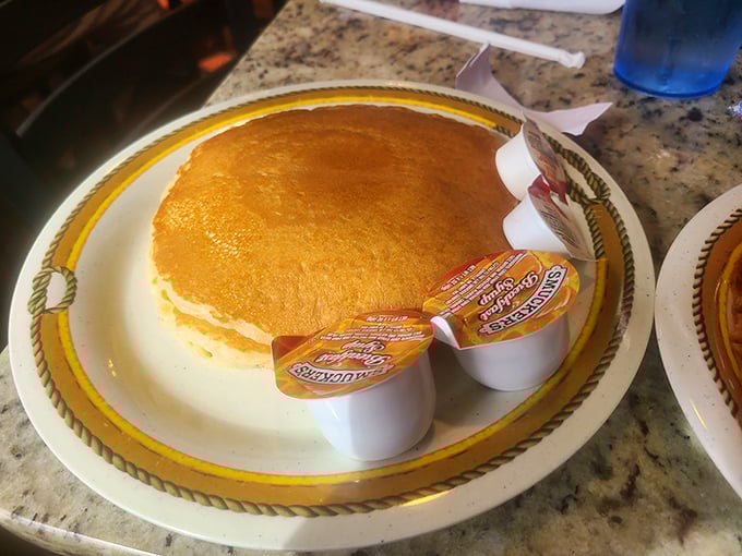 The pancake that ate Manhattan! Golden, fluffy, and approximately the size of a small frisbee – breakfast engineering at its finest.