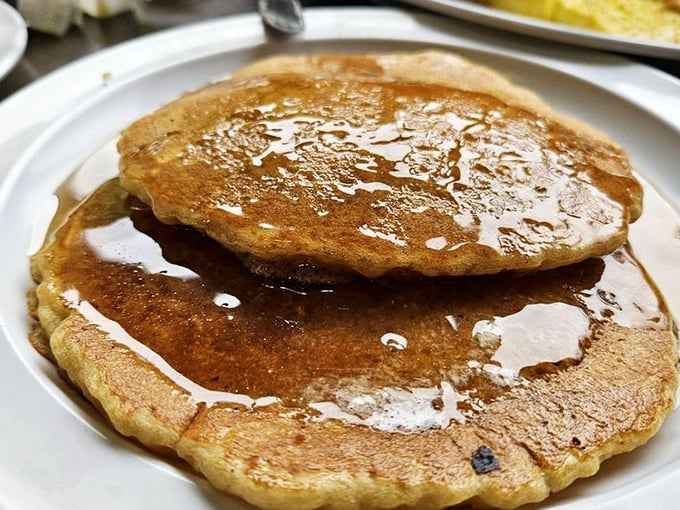 These pancakes aren't just round—they're perfect golden discs of happiness, glistening with maple syrup like morning sunshine after a rainstorm.