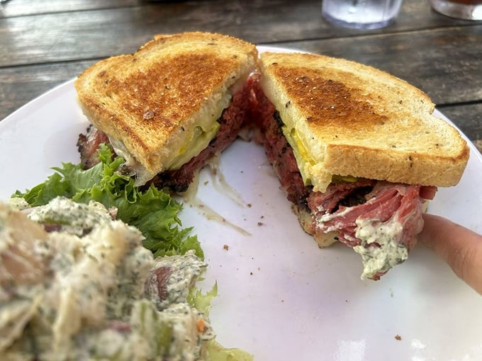 A pastrami sandwich that doesn't mess around—pink, peppery meat stacked generously between toasted bread with just enough greens for plausible deniability.