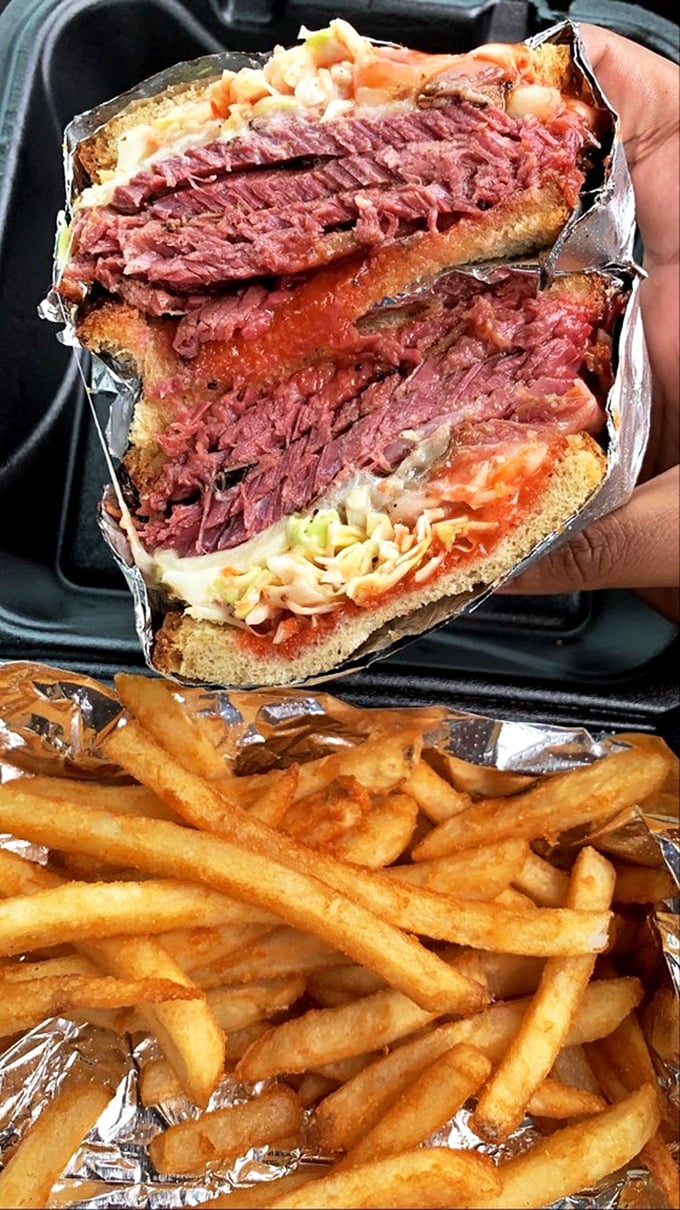 This sandwich isn't just lunch—it's an architectural marvel of smoked meat, coleslaw, and sauce that requires both hands and absolutely no dignity to consume properly.