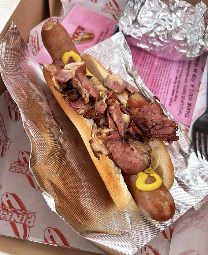 This isn't just a hot dog with pastrami—it's a meat summit where two deli favorites decided to share the spotlight.