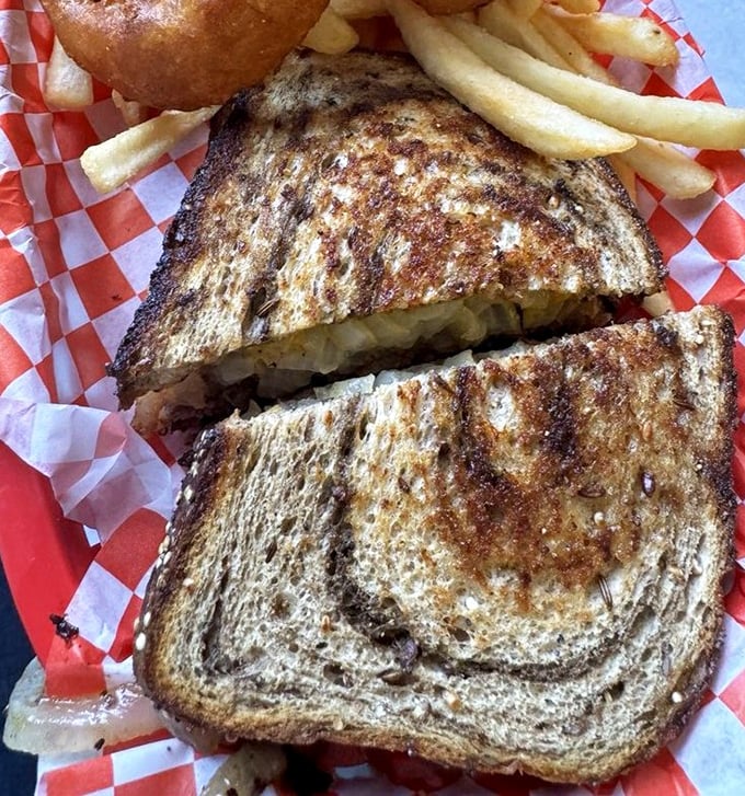 The patty melt – that perfect marriage of grilled bread and melted cheese. Served on classic red-checkered paper that practically screams "authentic diner."