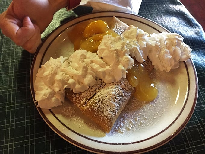 French crepes playing dress-up in their Tennessee Sunday best—whipped cream mountains atop peach-filled valleys of deliciousness.