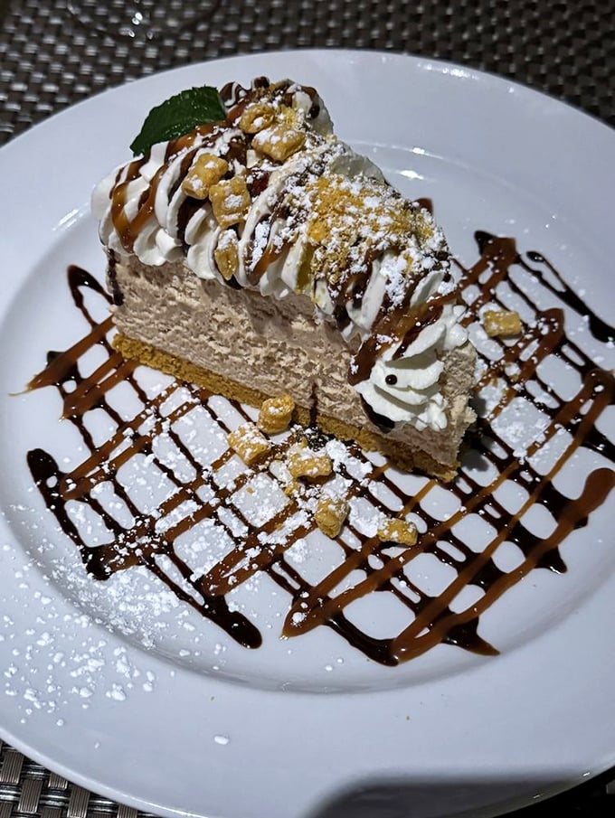 Not just dessert, but an architectural masterpiece of cream, chocolate, and what appears to be peanut butter—calories worth every delicious bite.