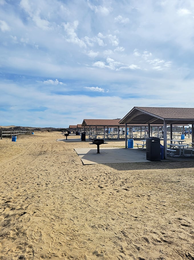 Covered picnic shelters offer a shaded sanctuary for beach lunches, proving someone brilliantly understood that sand belongs on your feet, not your sandwich.
