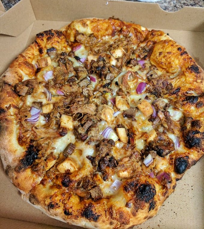 Wood-fired pizza that doesn't play by the rules – this pie combines smoky, charred perfection with toppings that would make an Italian grandmother both confused and proud.