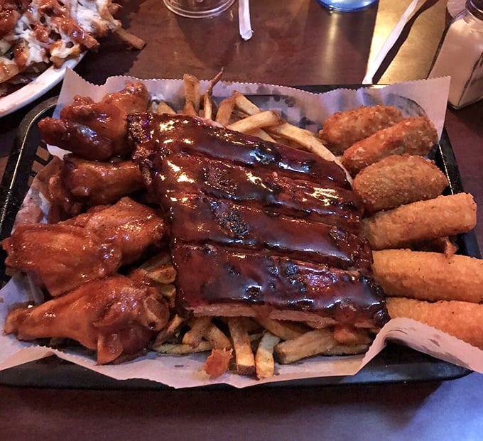 This isn't just a platter—it's a barbecue United Nations where ribs, wings, and sides have gathered to form a delicious alliance on a bed of fries.