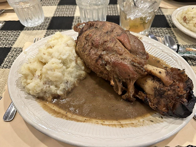 This pork shank isn't just fall-off-the-bone tender—it practically leapt off the bone to dive into that savory gravy lake. Mashed potato island included.