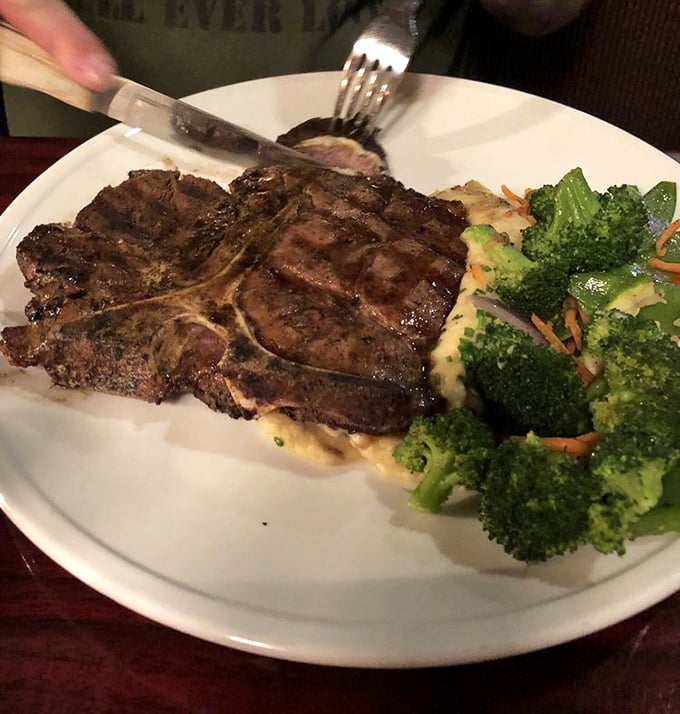 Behold the porterhouse in its natural habitat—perfectly seared, resting beside fresh broccoli and mashed potatoes. This isn't just dinner; it's a celebration on a plate.