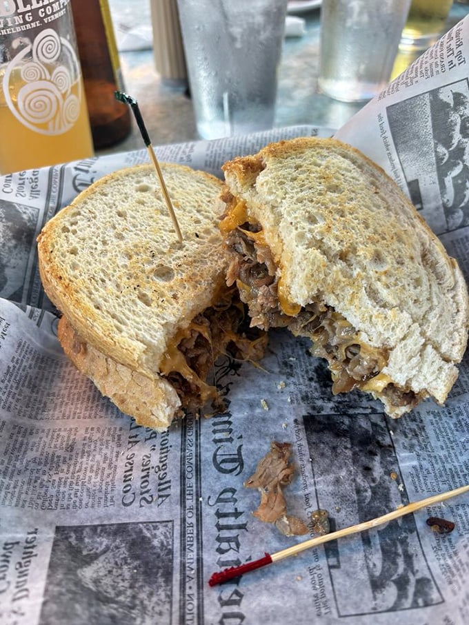 This sandwich isn't messing around—tender prime rib nestled between toasty bread with melty cheese that's having the time of its life. Half-eaten because nobody has that much willpower.