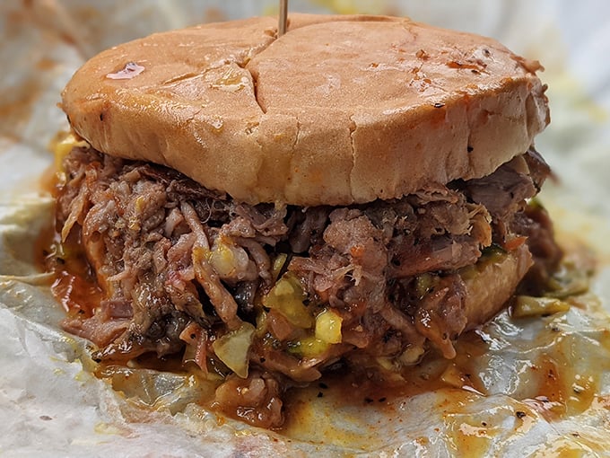 The pulled pork sandwich in its natural habitat—gloriously messy, unapologetically delicious, and worth every napkin you'll sacrifice to the barbecue gods.