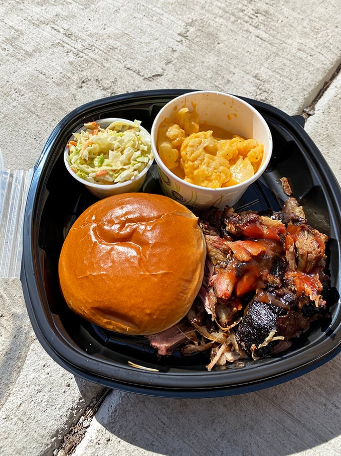 The barbecue trifecta: tender pulled meat, creamy mac and cheese, and fresh slaw – a to-go container that's practically begging to be photographed before devouring.