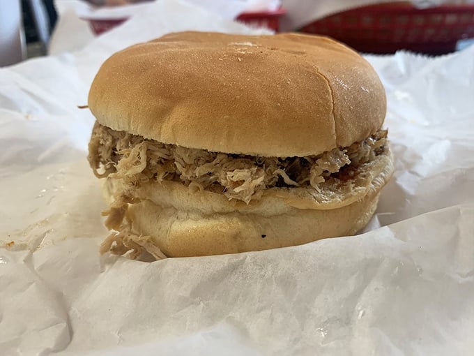 The pulled pork sandwich in its purest form – no fancy garnishes needed when the meat has been kissed by smoke for hours and tucked into a pillowy bun.