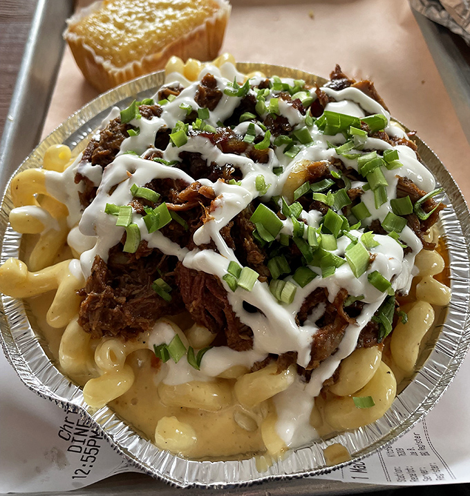 Mac and cheese topped with pulled pork and drizzled with sauce—because sometimes the best things in life are the ones that require an extra napkin or three.