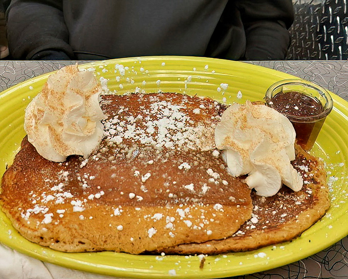 These pancakes aren't just a meal, they're an event—crowned with whipped cream and powdered sugar like royalty of the breakfast kingdom.