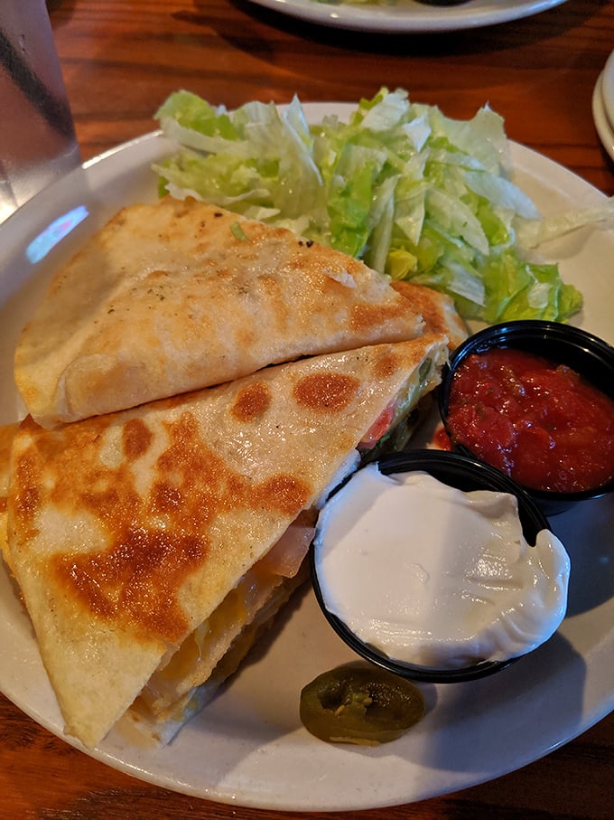 This quesadilla isn't playing around – perfectly crisped tortilla, melty cheese, and those dipping sauces? The holy trinity of Tex-Mex comfort.