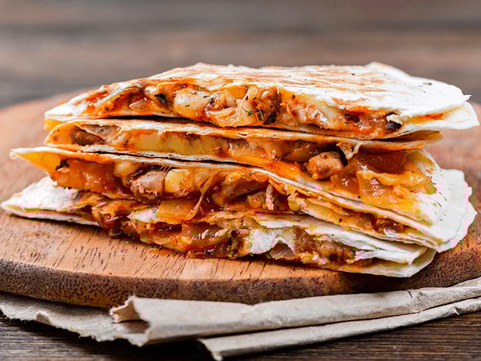 Quesadillas that don't just cross borders—they demolish them. Stuffed with enough filling to make you wonder if they're charging by the pound.