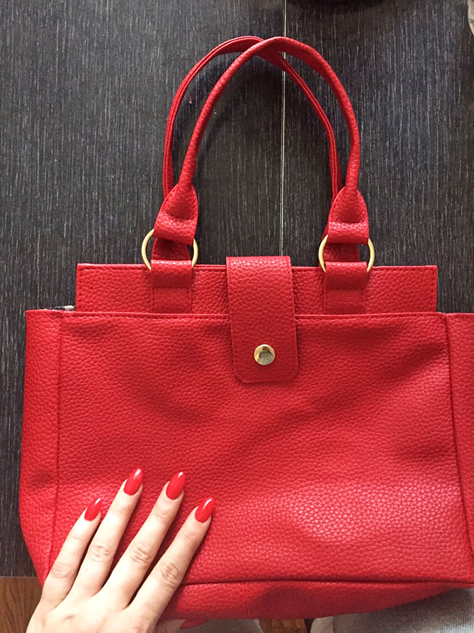 That red handbag knows secrets and has attended galas—now it's ready for your story.