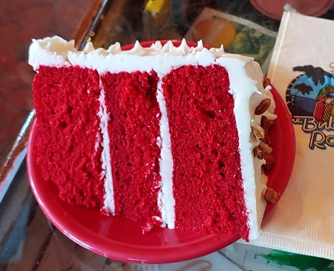 The red velvet cake stands tall as a crimson monument to everything dessert should be – dramatic, decadent, and delightful.